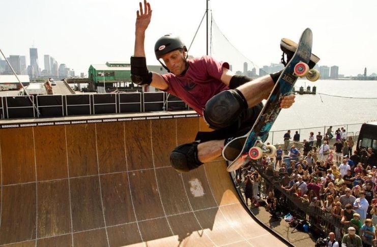 Tony Hawk faz uma incrível manobra enquanto segura um copo de leite ...